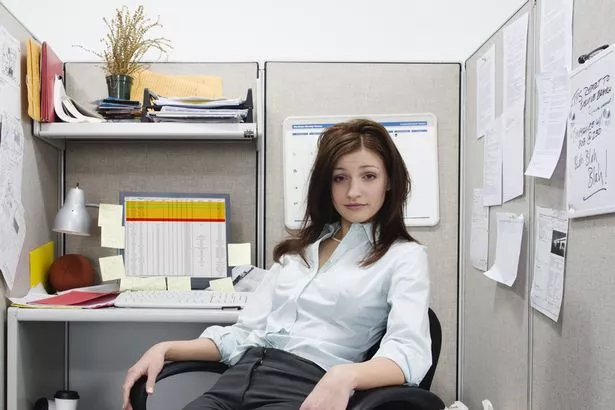Female office worker slouching in messy cubicle portrait — Postimages