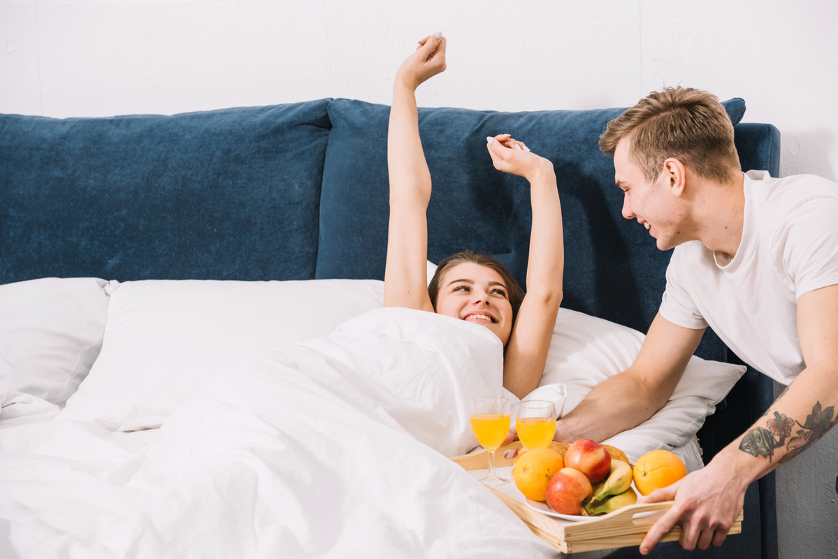 man holding tray of food for waking up woman — Postimages