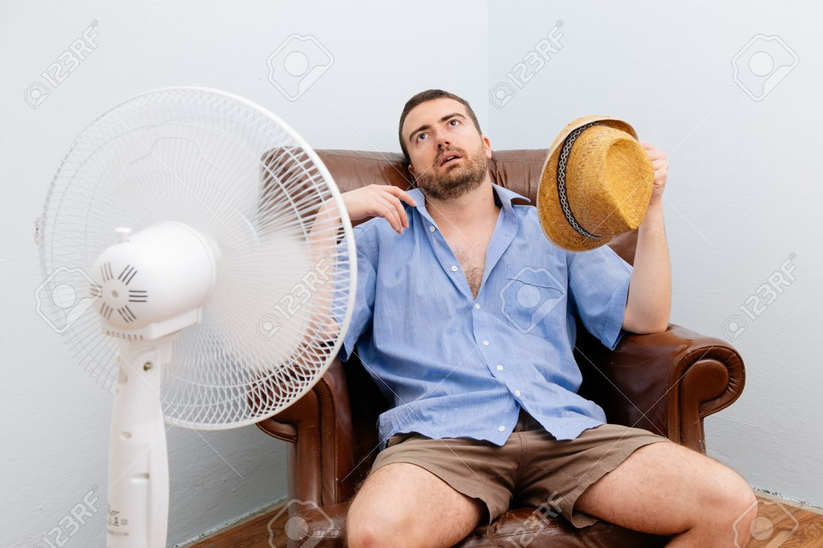 62892919 flushed man feeling hot in front of a fan — Postimages